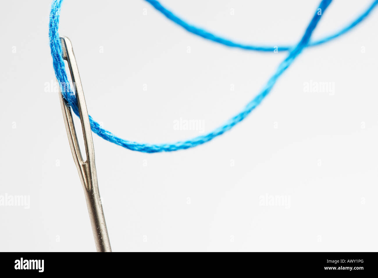 Blue thread going through needle eye, close-up Stock Photo - Alamy