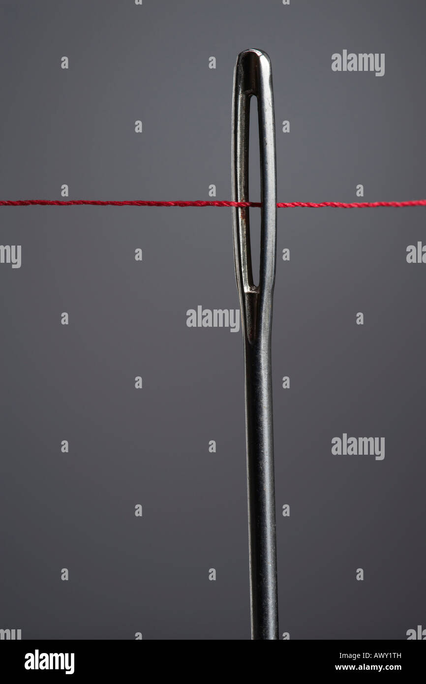 Red thread going through needle eye, close-up Stock Photo - Alamy