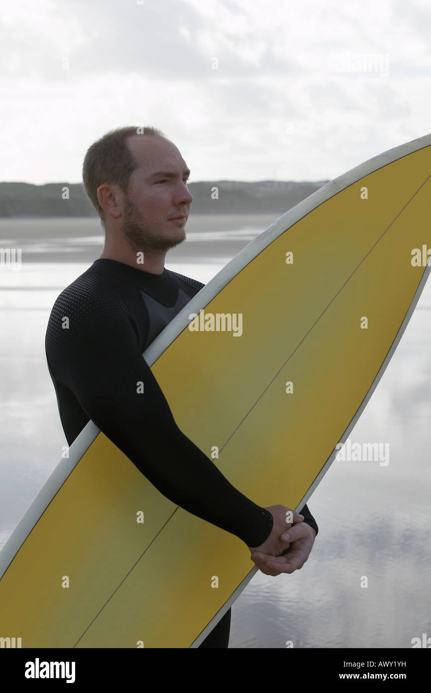 Man holding surfboard on beach Stock Photo - Alamy