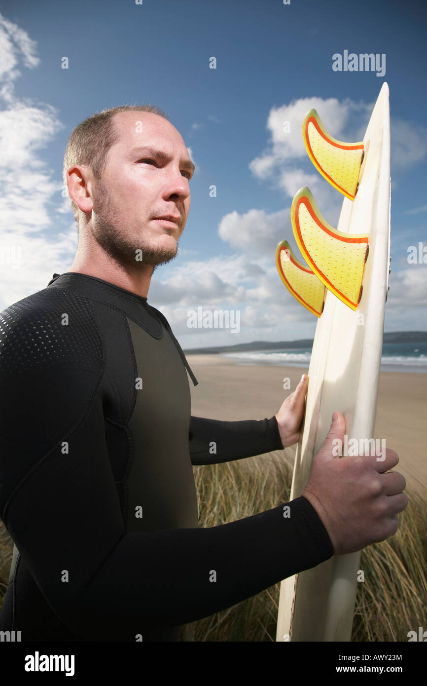 Man holding surfboard on beach Stock Photo - Alamy