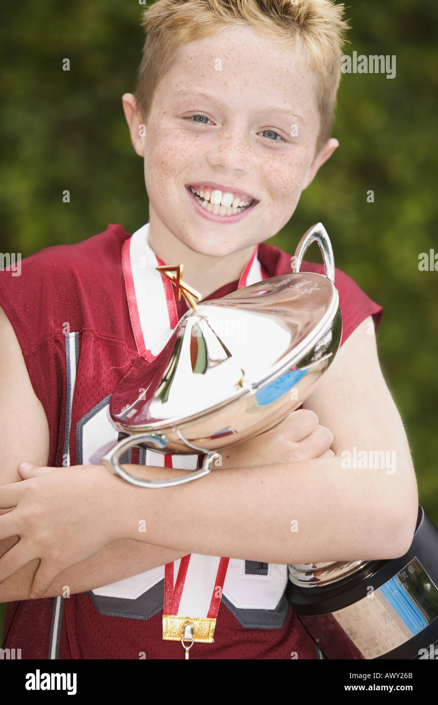 Portrait of a boy hugging a trophy Stock Photo - Alamy