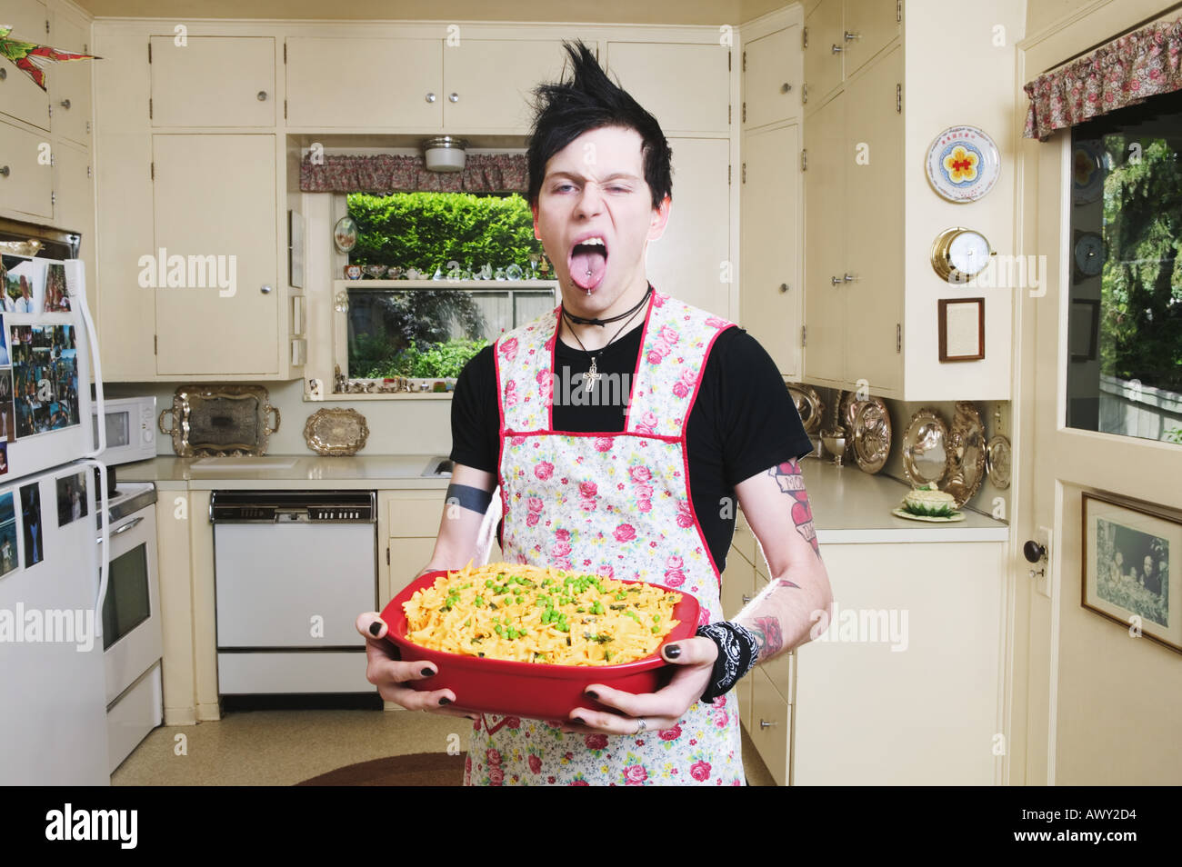 Man in the kitchen holding a casserole Stock Photo - Alamy