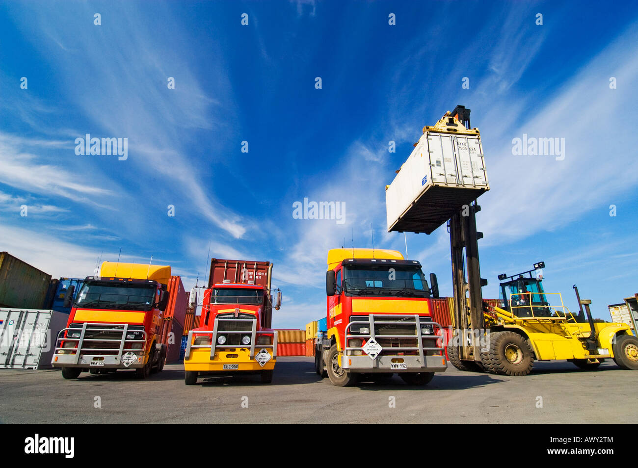 Lift truck loading shipping containers onto trucks Stock Photo - Alamy