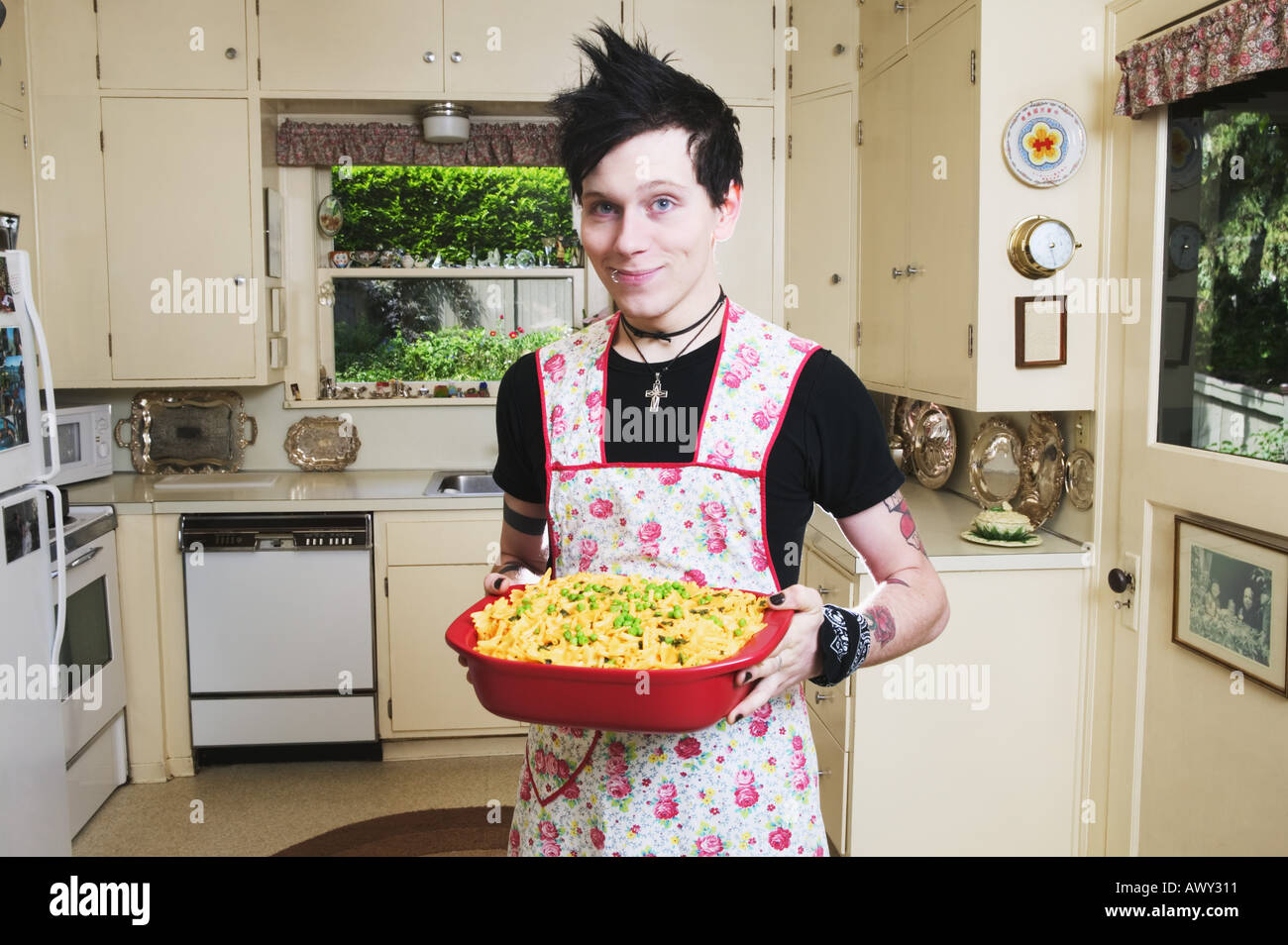 Man in kitchen holding a casserole Stock Photo - Alamy