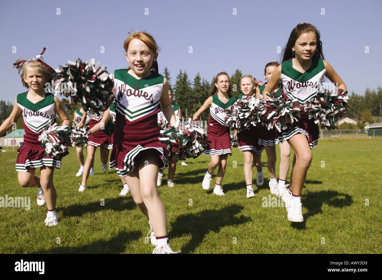 Cheerleaders running on an athletic field Stock Photo - Alamy