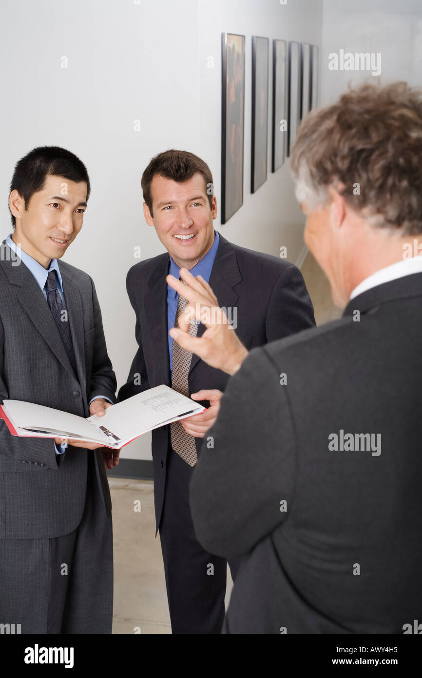 Businessmen Talking in Office Hallway Stock Photo - Alamy