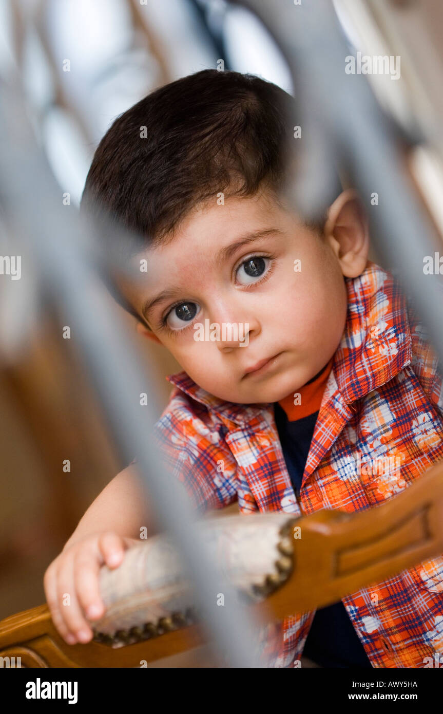 Portrait of young boy looking through the gate Stock Photo - Alamy