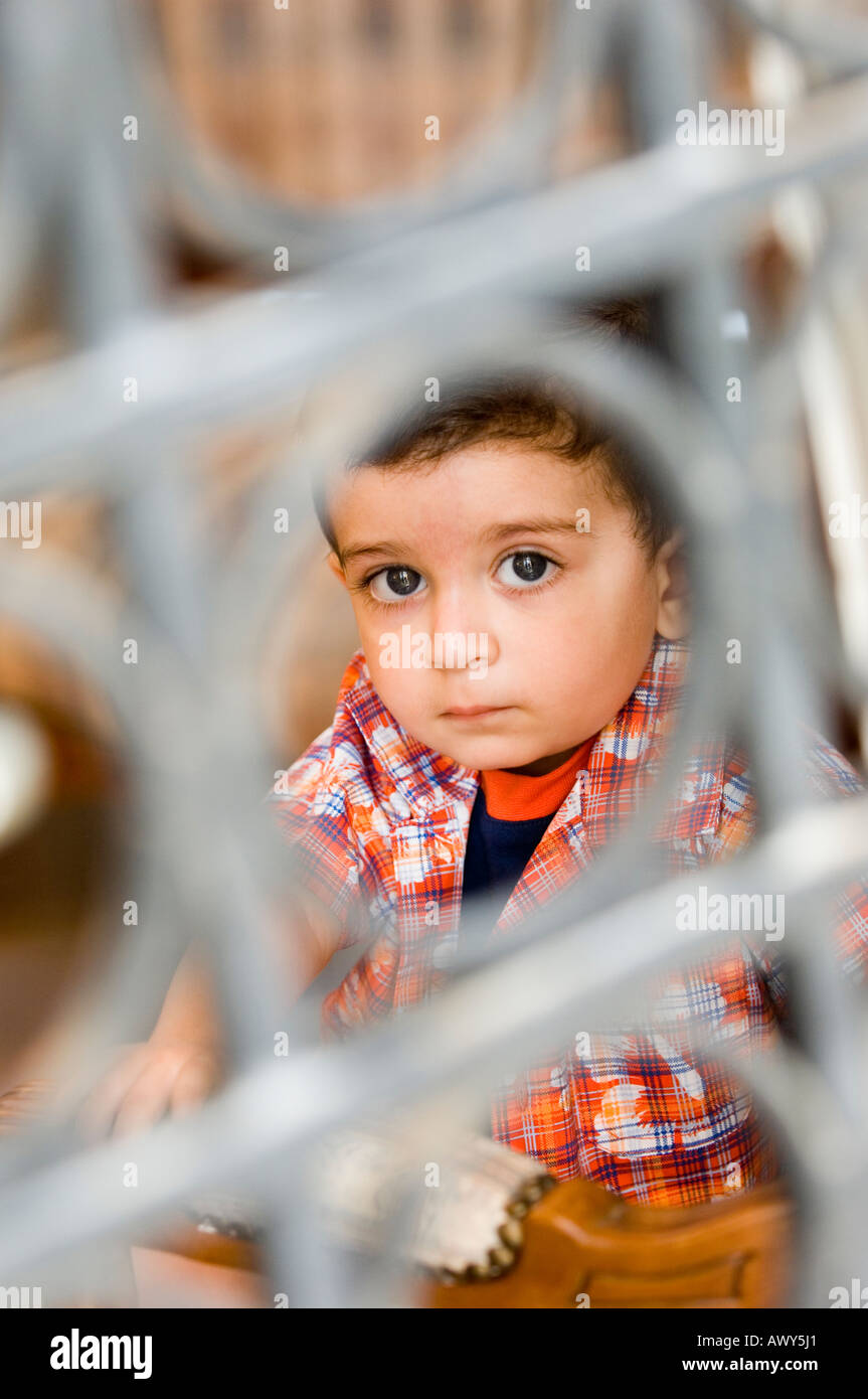 2 years old boy looking through the gate Stock Photo - Alamy