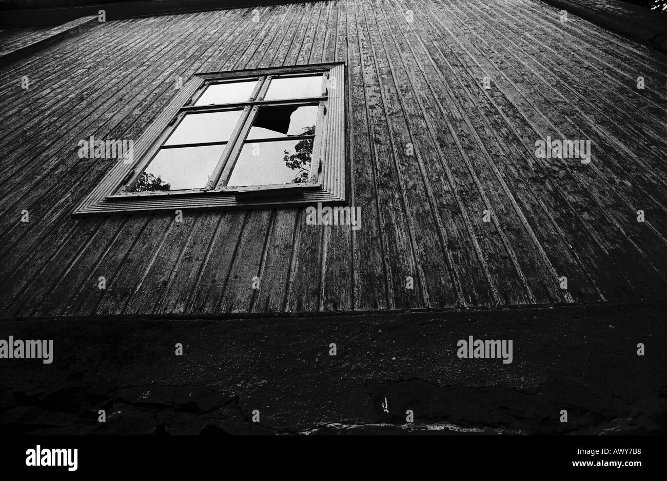 Derelict wooden house with broken window in a perspective looking up ...