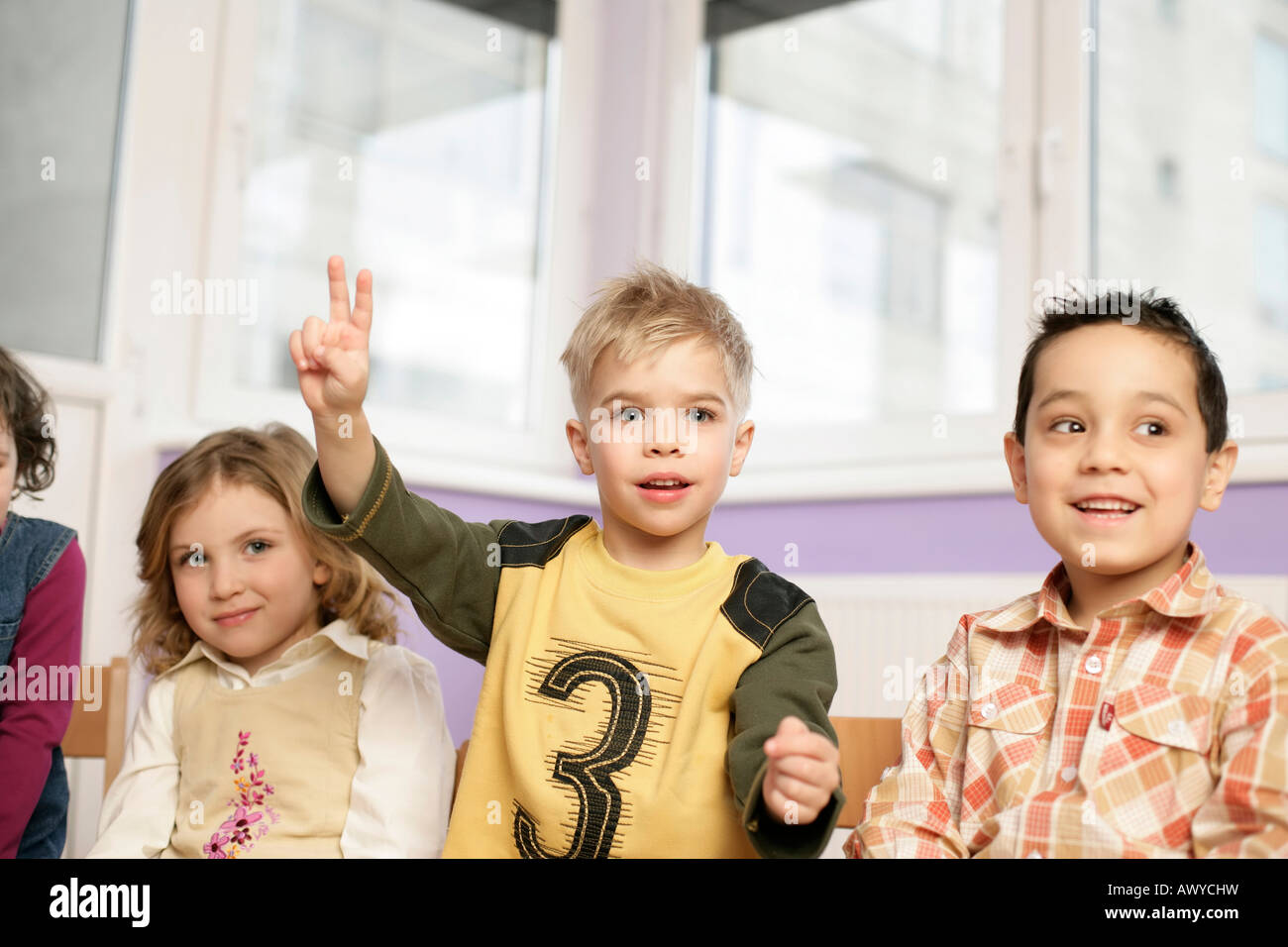 Group of children, one boy raising up his hand Stock Photo - Alamy