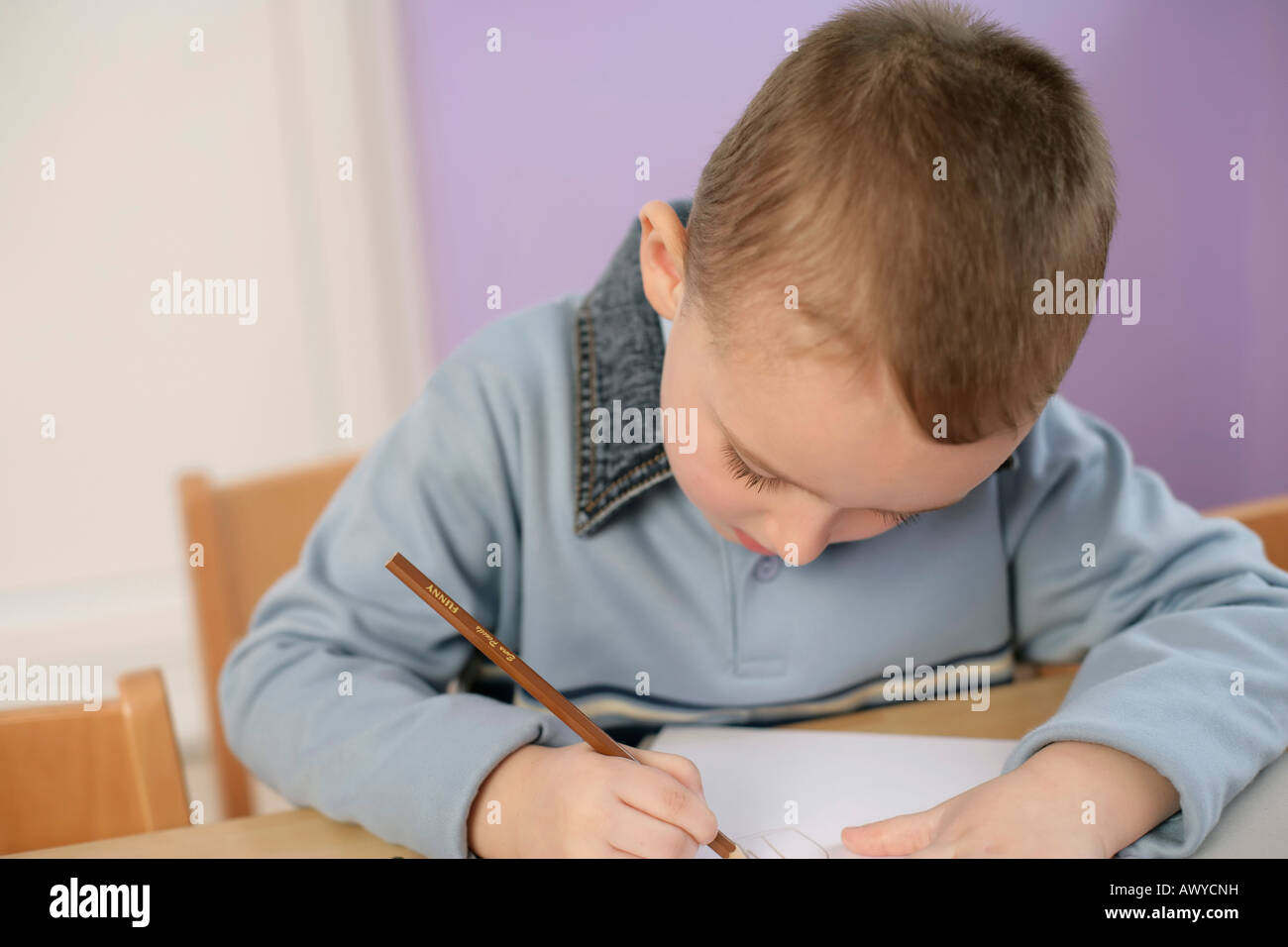 Boy drawing, sitting on chair Stock Photo - Alamy