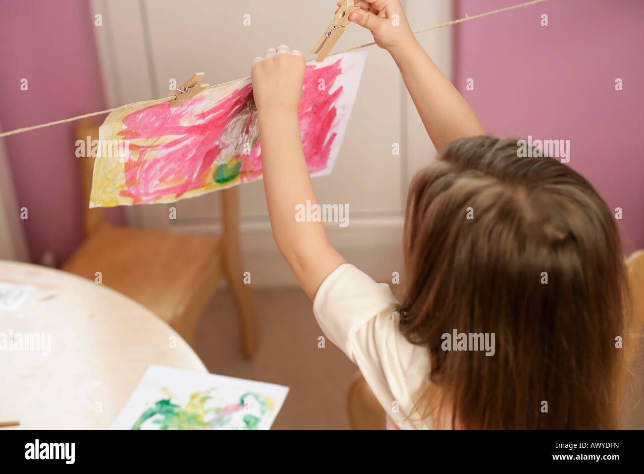 Girl hanging up painting hi-res stock photography and images - Alamy