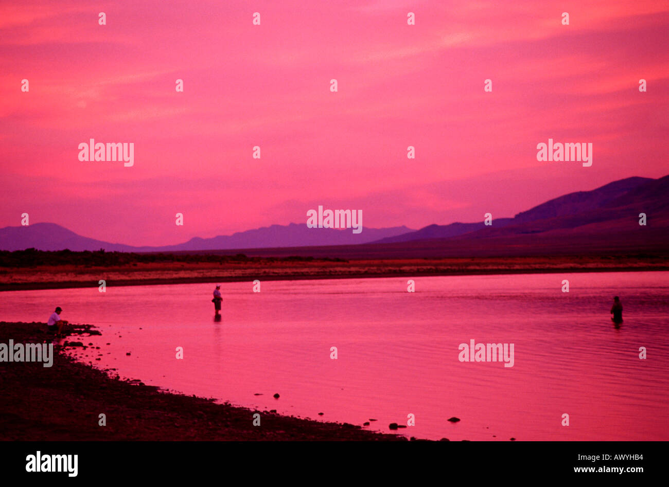 silhouette men flyfishing at sunset wading in Mann Lake Northern Great ...