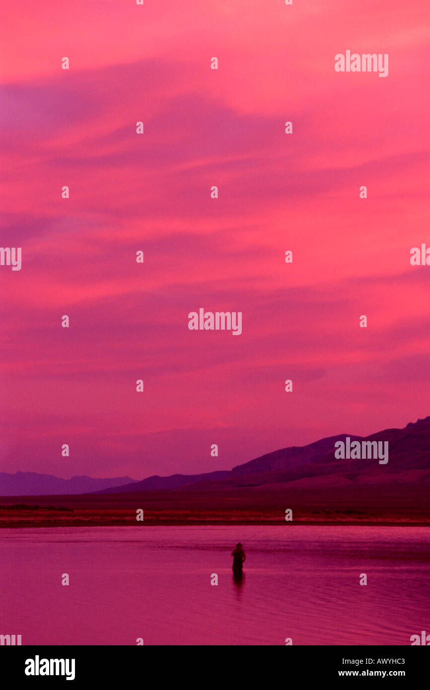 silhouette man flyfishing at sunset wading in Mann Lake Northern Great ...