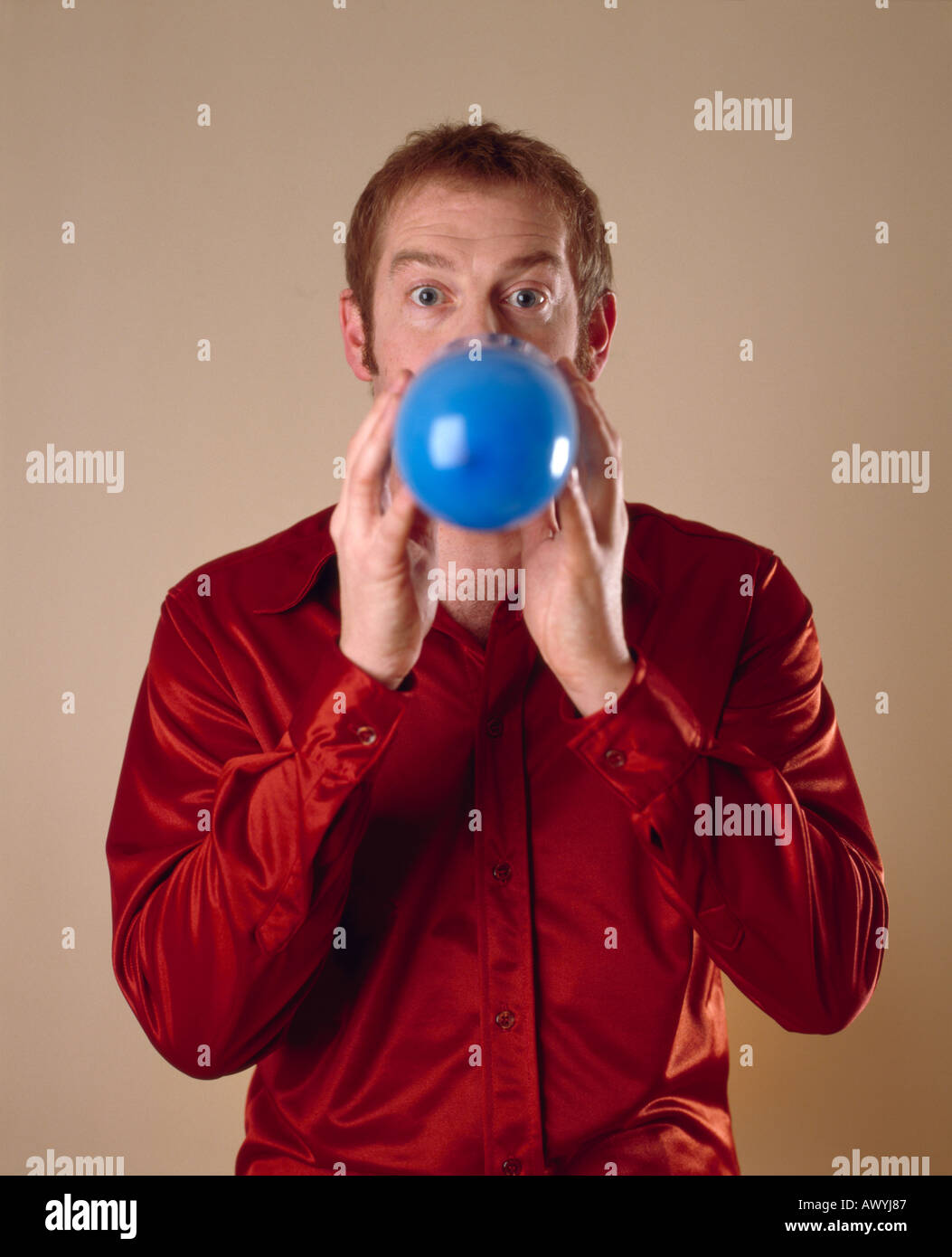 Man blowing up a balloon Stock Photo - Alamy