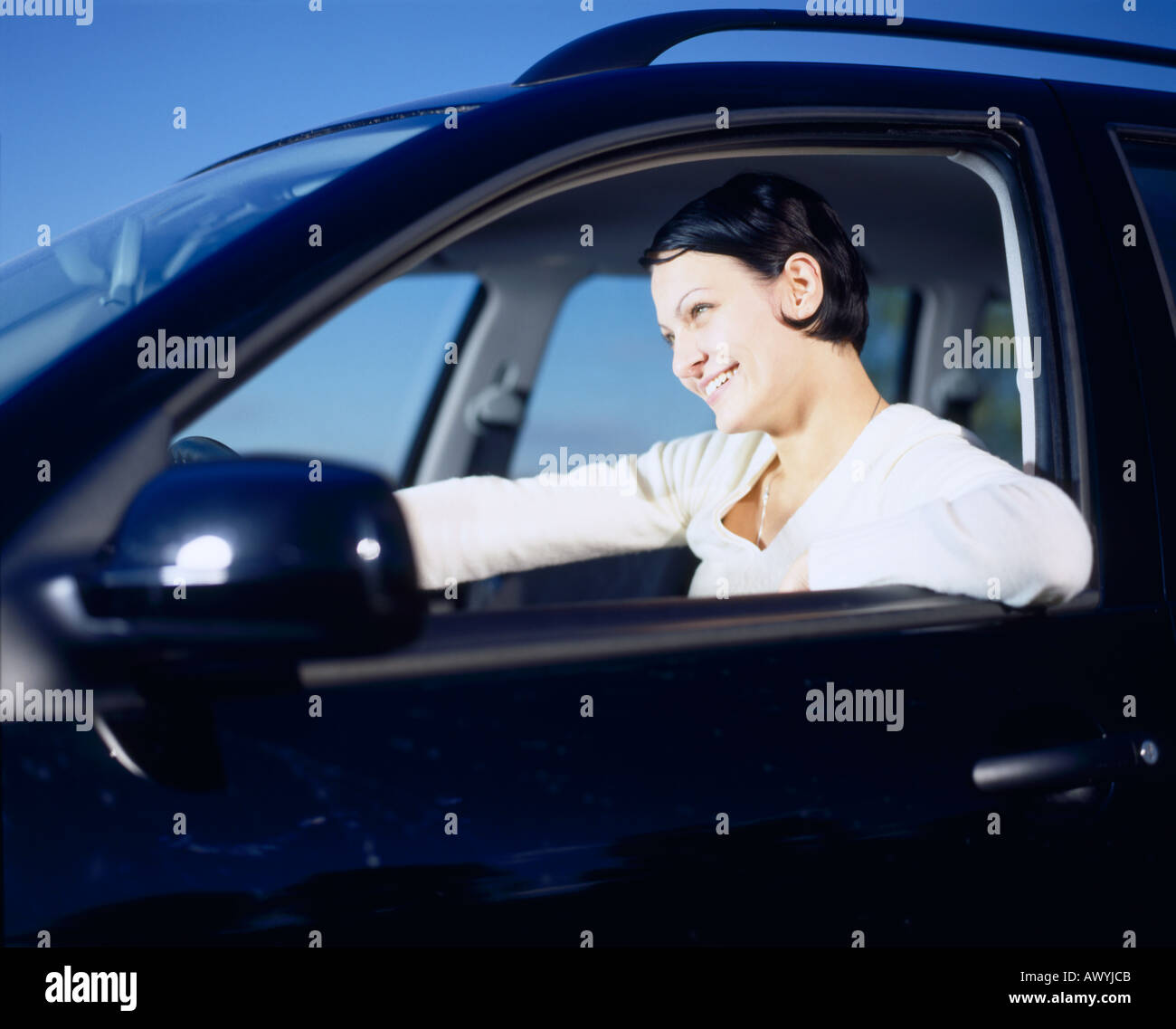 Young woman driving car - side view Stock Photo - Alamy