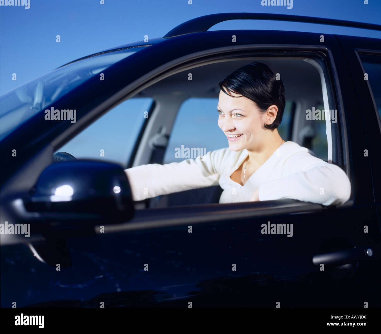 Young woman driving car - side view Stock Photo - Alamy