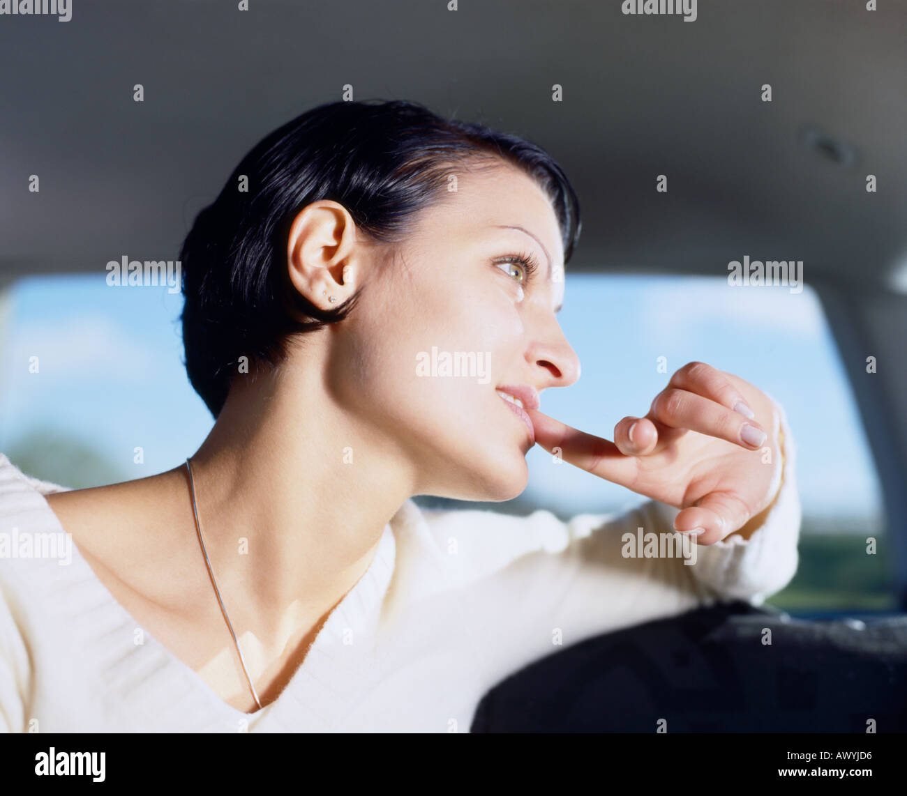 Young lady in back seat of car looking out window - head and shoulders ...