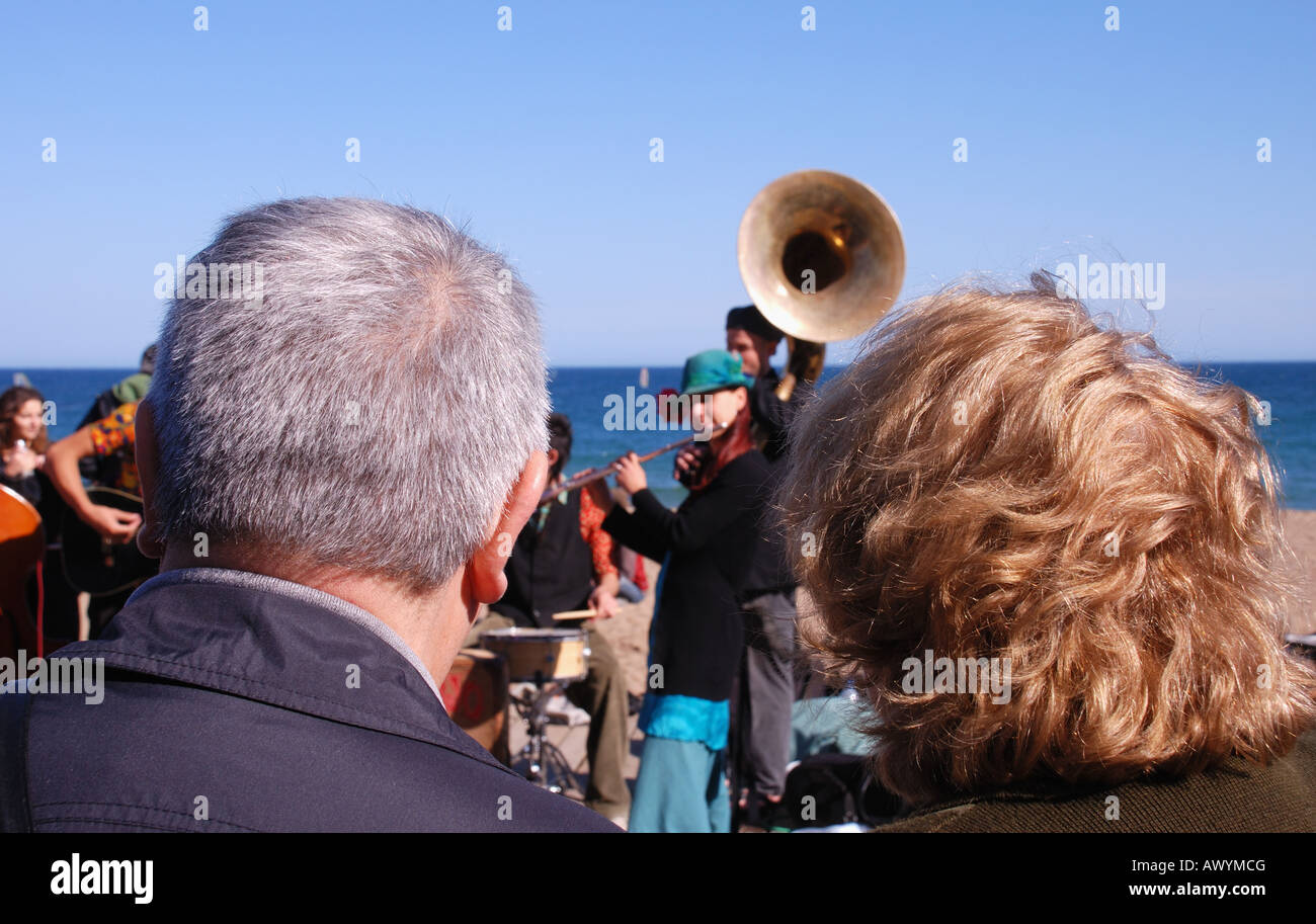 A couple looking at an street music band in the Barceloneta beach in ...