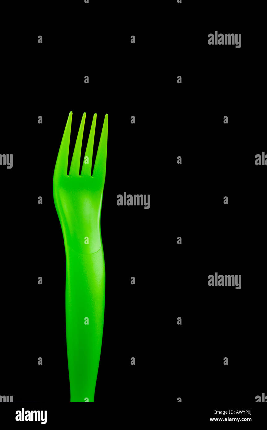 Fluorescent green plastic fork with black background Stock Photo - Alamy