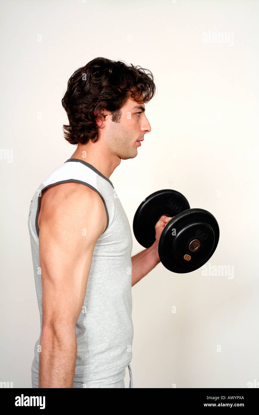 Young man lifting weights Stock Photo - Alamy
