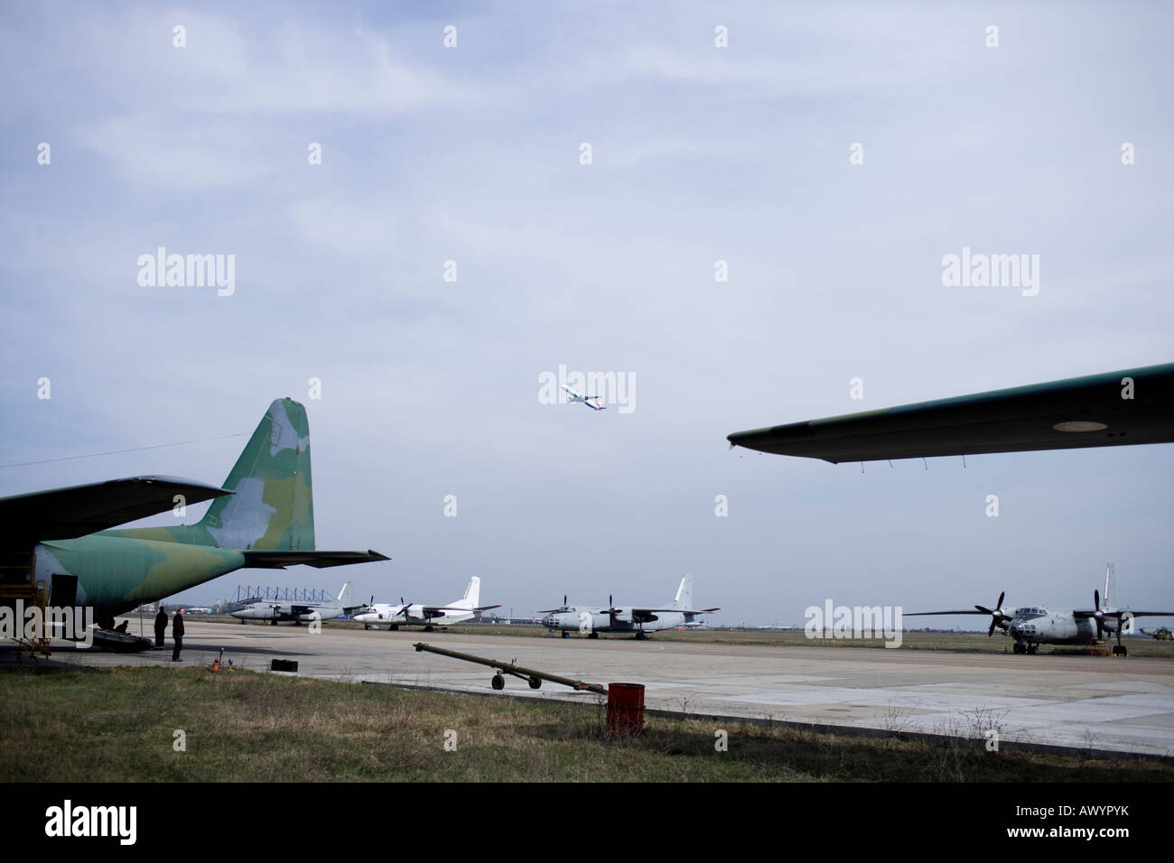 many airplanes on runway and one flying up in the sky Stock Photo - Alamy