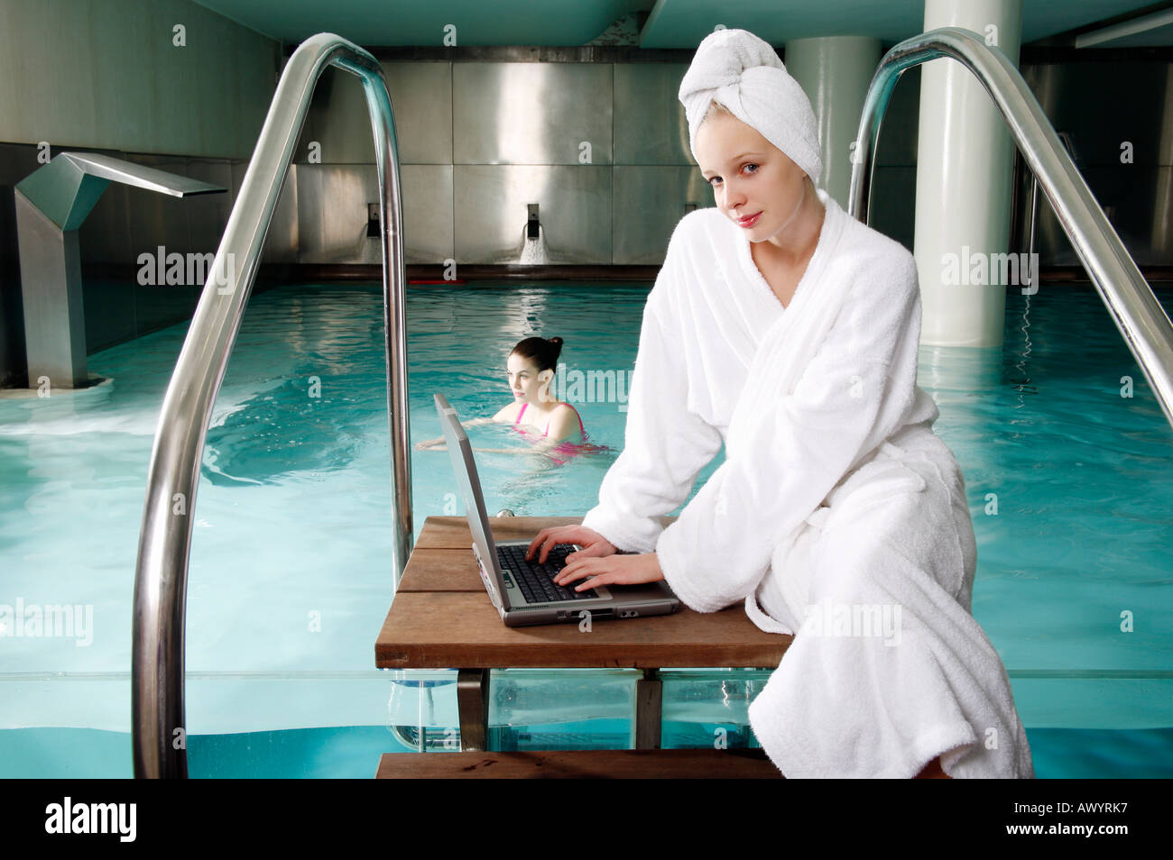 Woman on computer next to a swimming pool Stock Photo - Alamy
