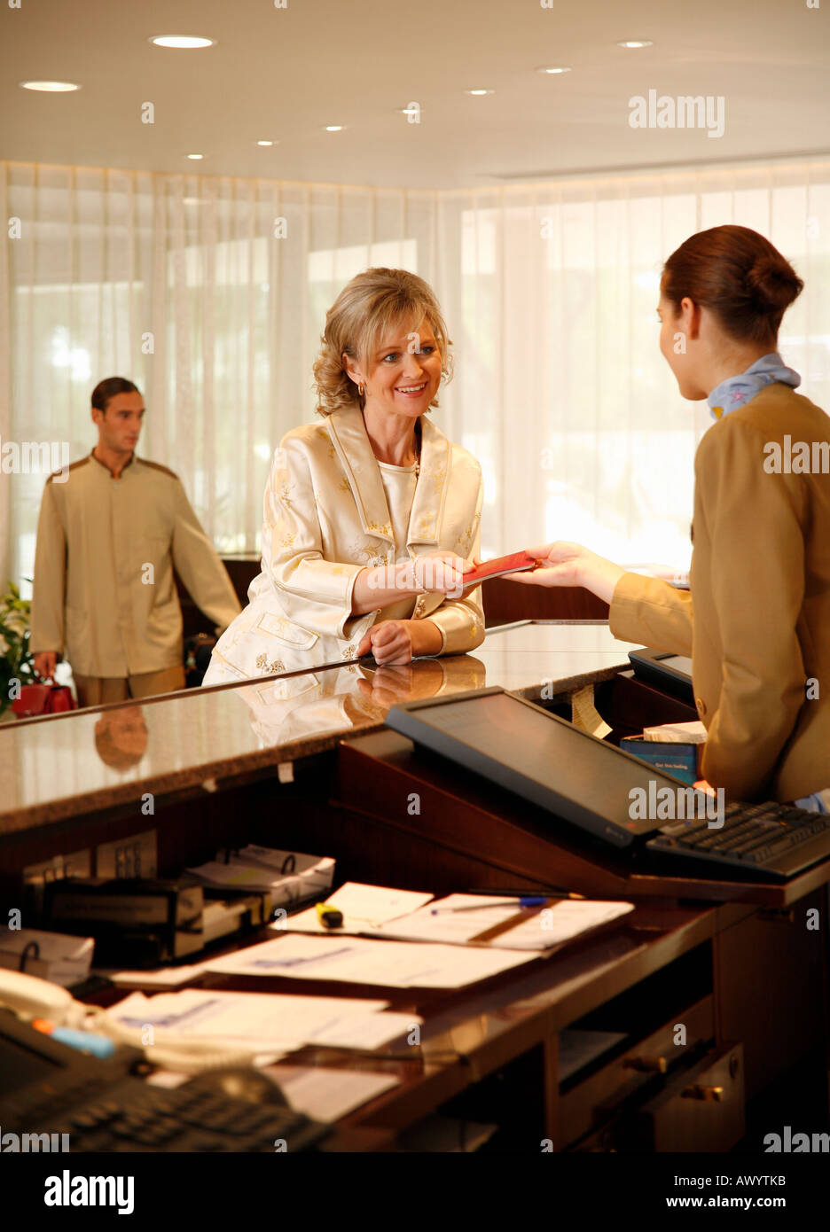 Woman checking in at the hotel reception desk Stock Photo - Alamy