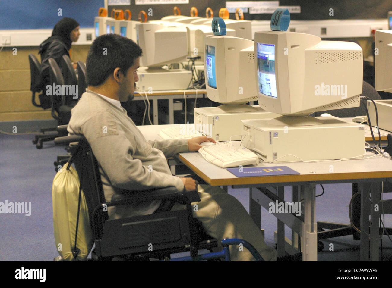 Student in wheelchair working at computer at 6th form college GB UK ...