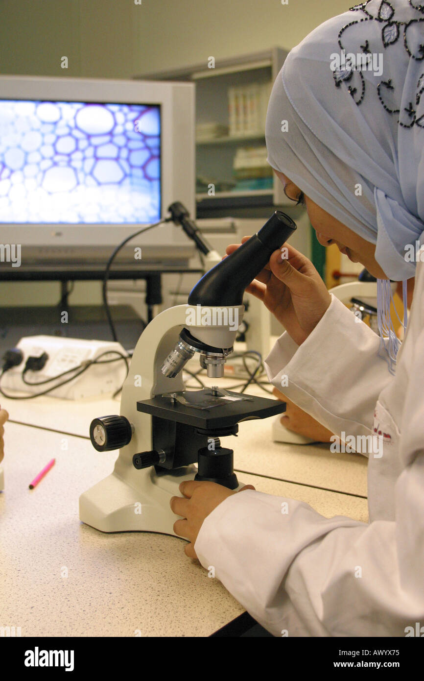 Female Sixth form Student looking through microscope in science ...