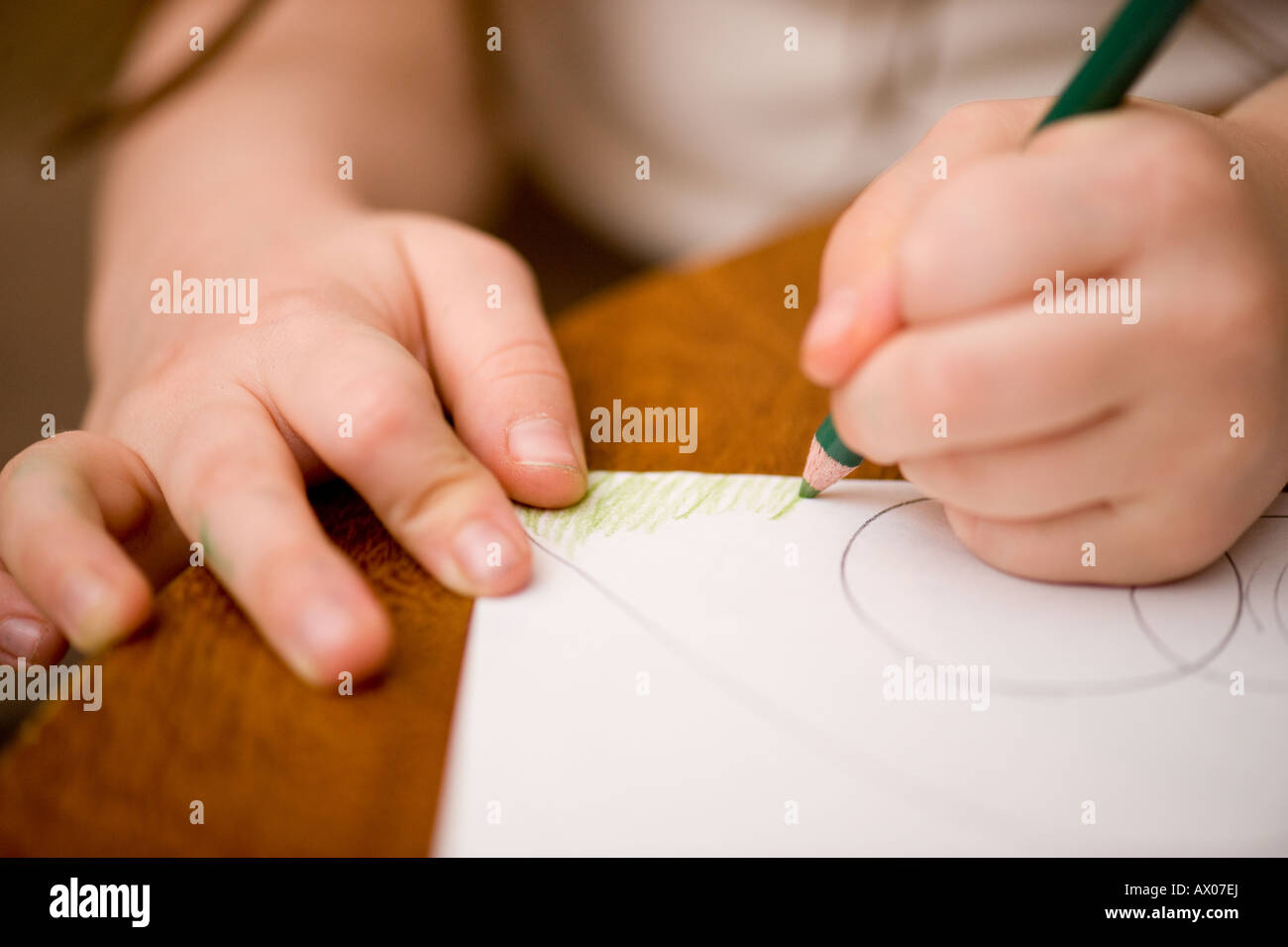 A child drawing with a green color pencil Stock Photo - Alamy