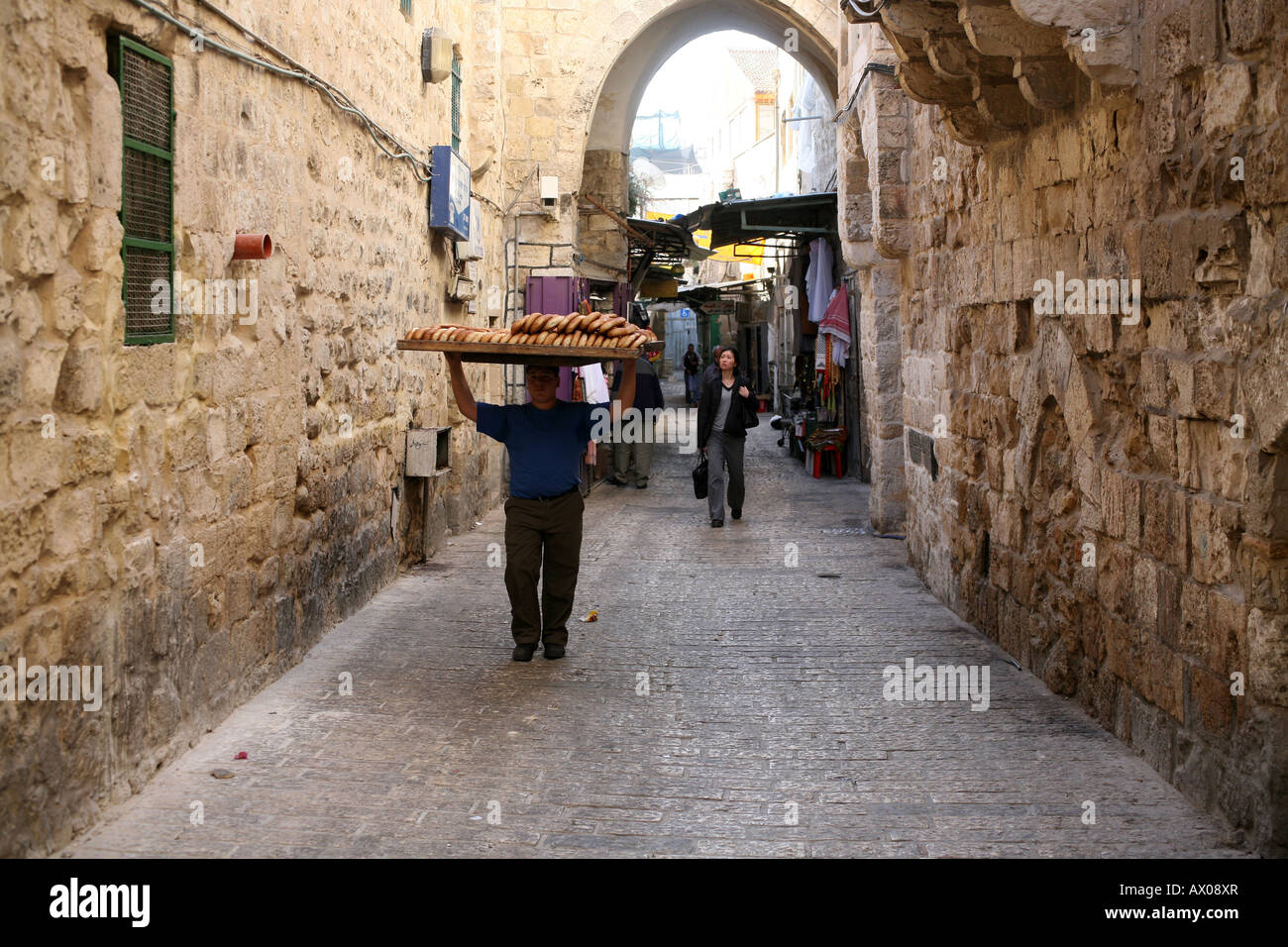 A man carrying bread through a market in the old city section of ...