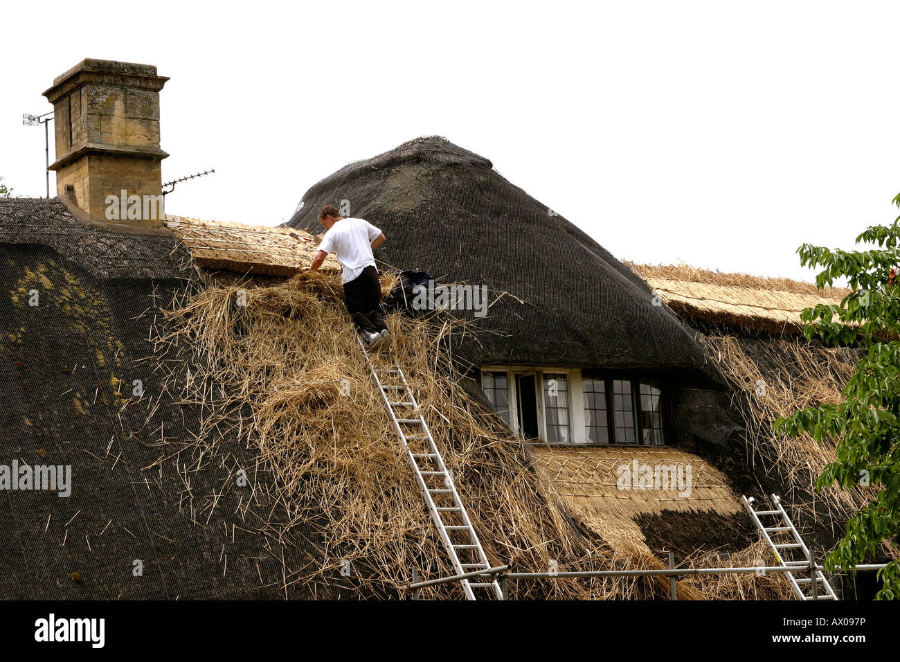 UK Worcestershire Stanton thatcher at work on roof Stock Photo - Alamy