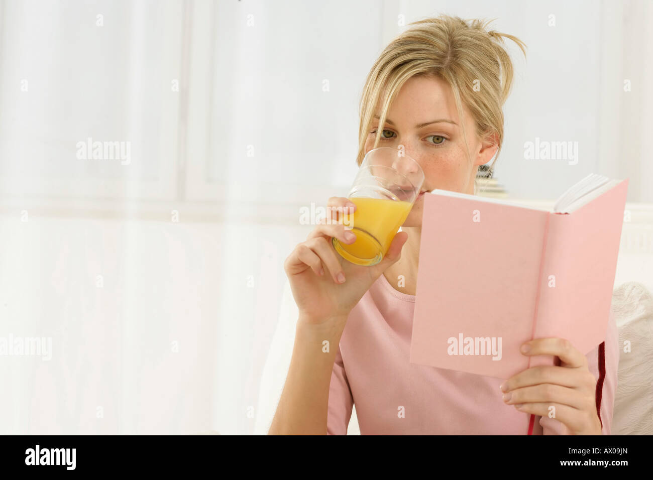 Woman reading a book, drinking juice Stock Photo - Alamy