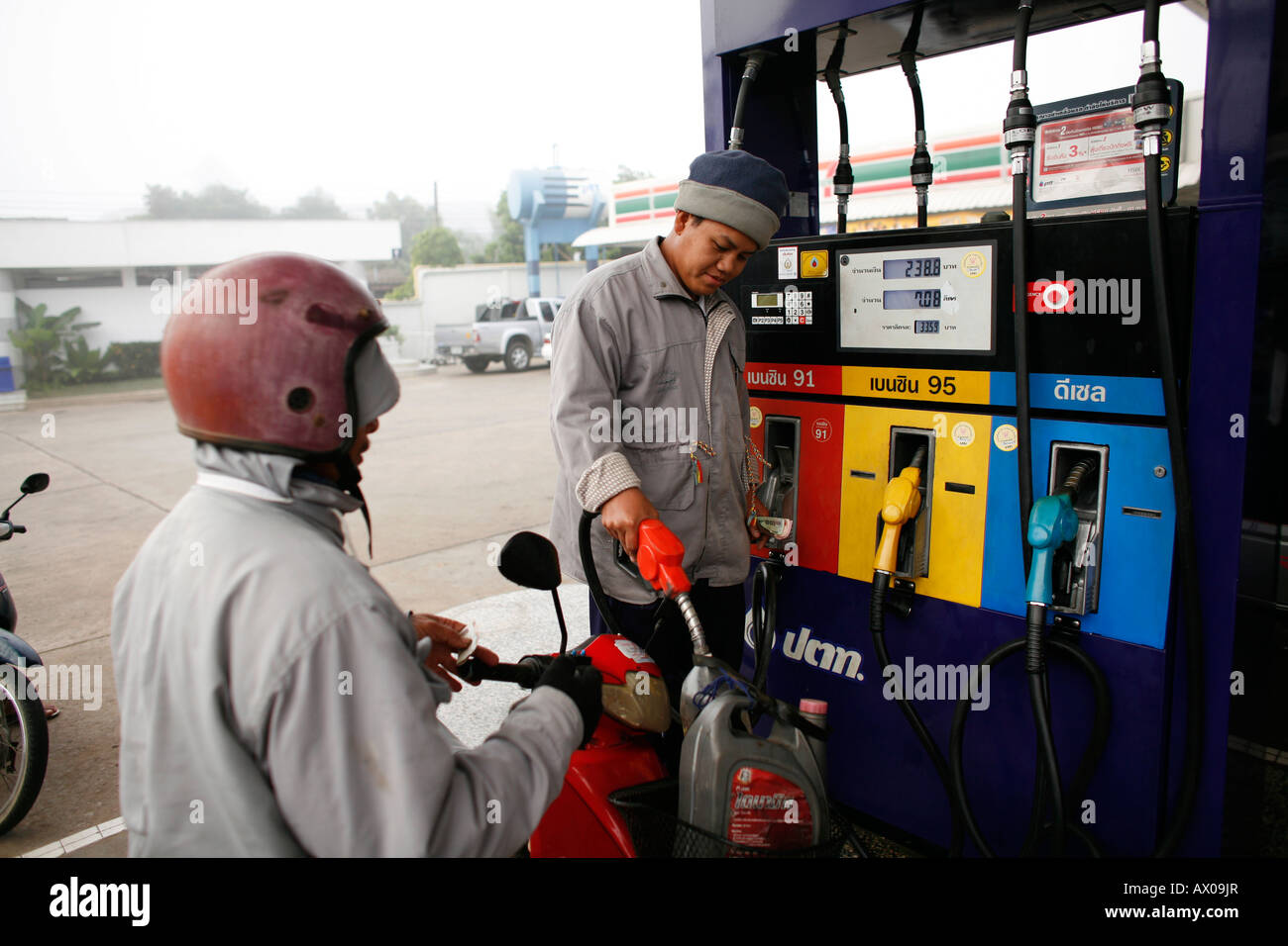 A moped rider waits while he gets petrol Stock Photo - Alamy