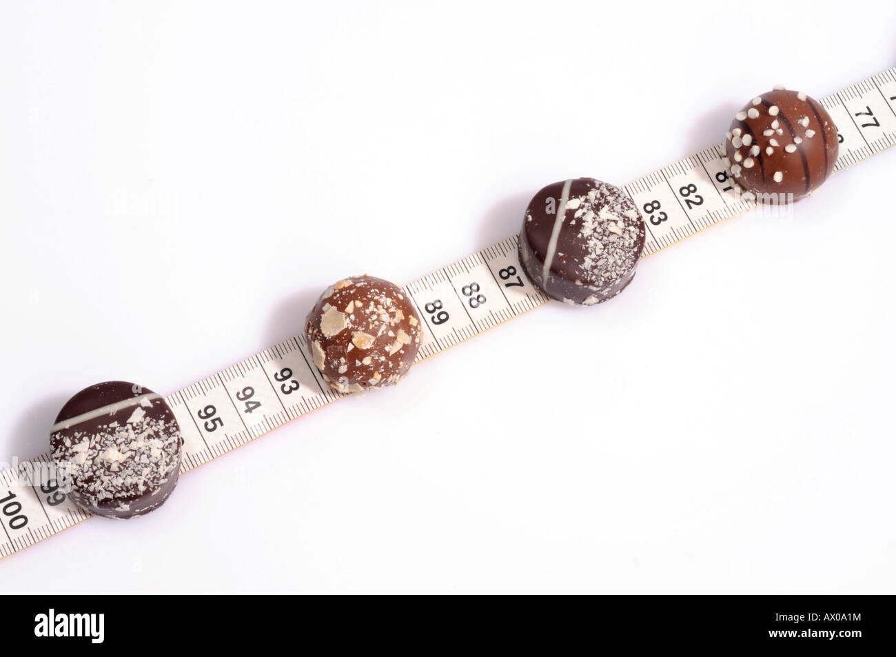 Chocolate pralines and a measuring tape Stock Photo - Alamy