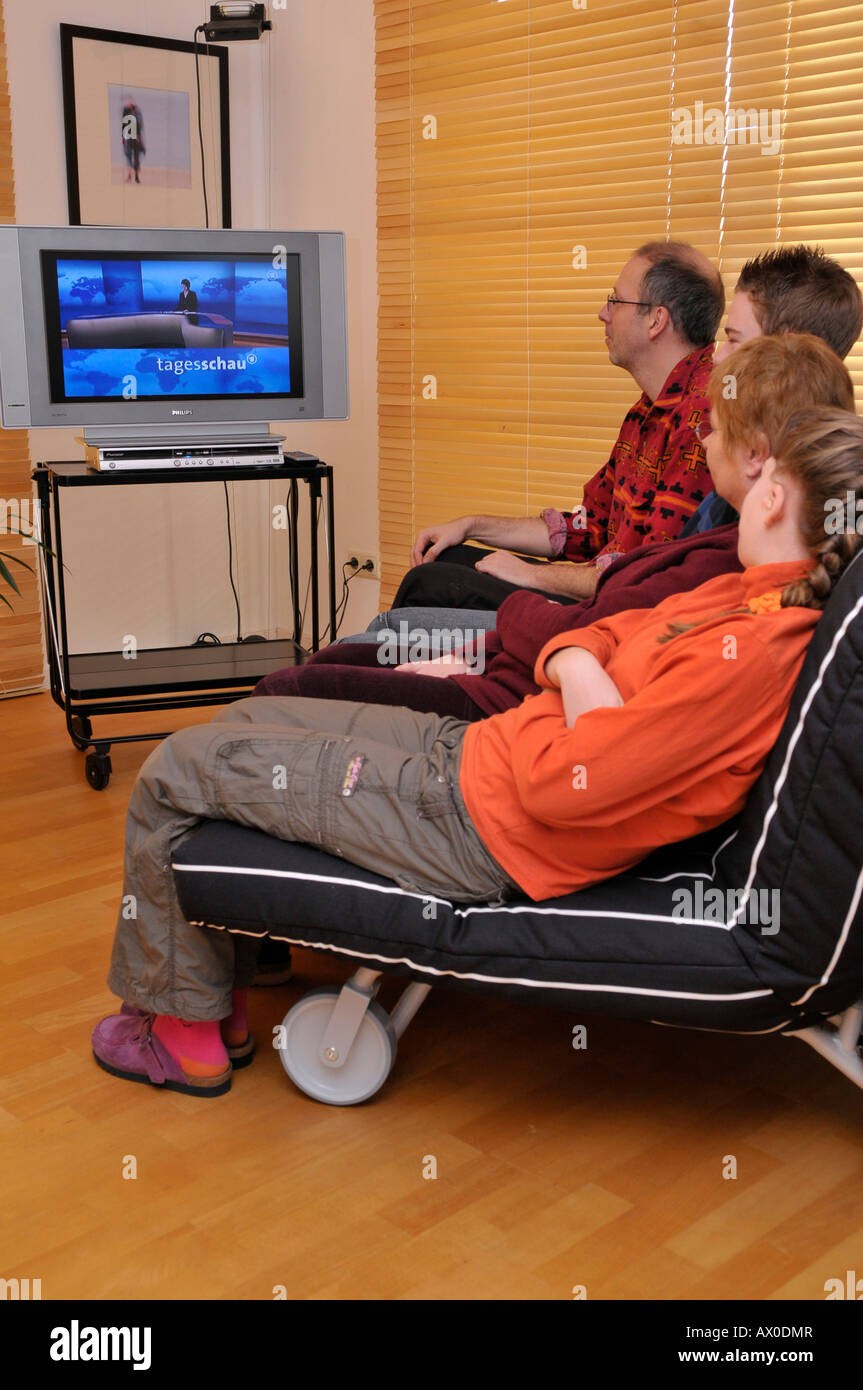 Family sitting on couch watching TV Stock Photo - Alamy Family sitting on couch watching TV Stock Photo - Alamy