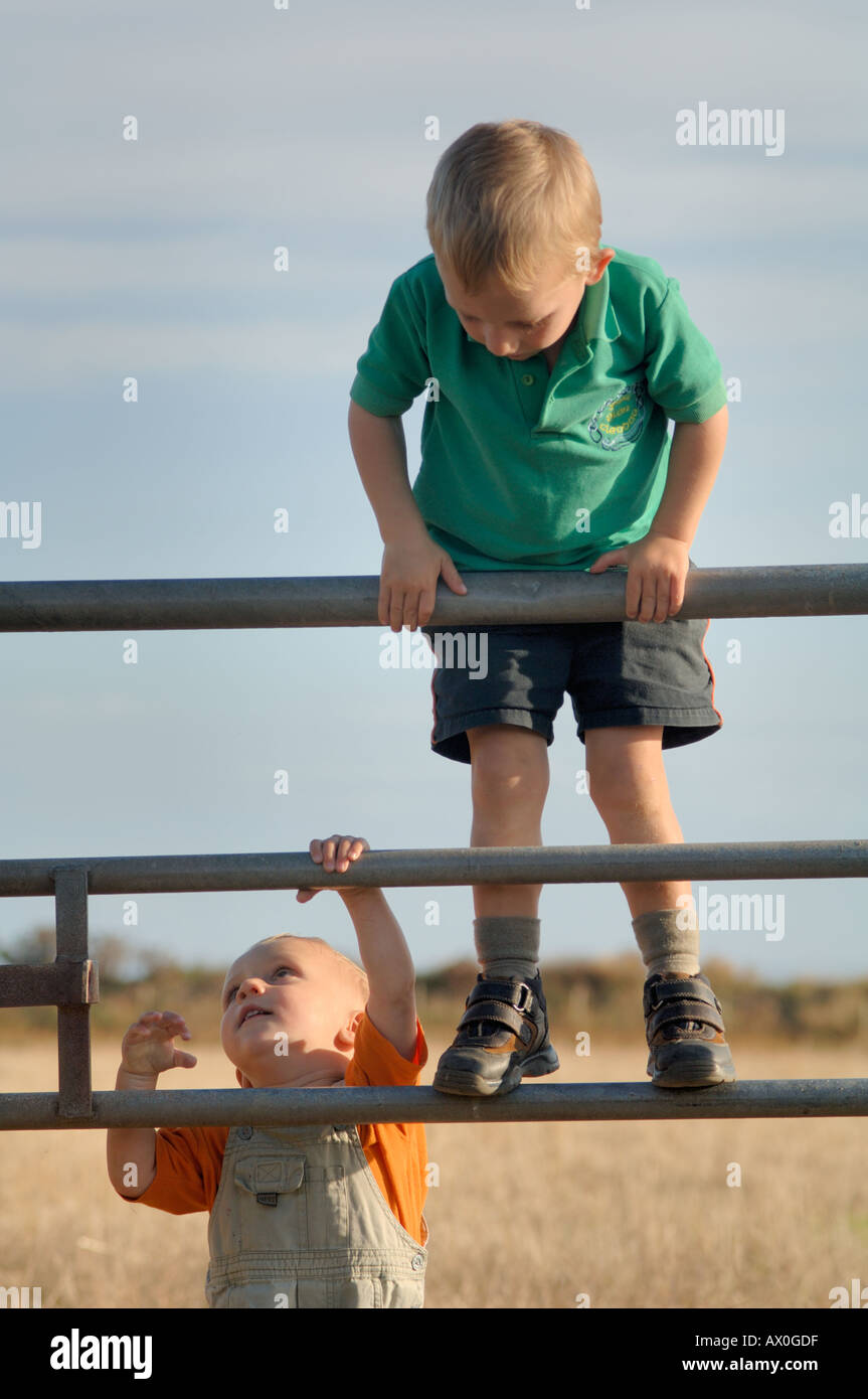 Boys climbing gate Stock Photo - Alamy