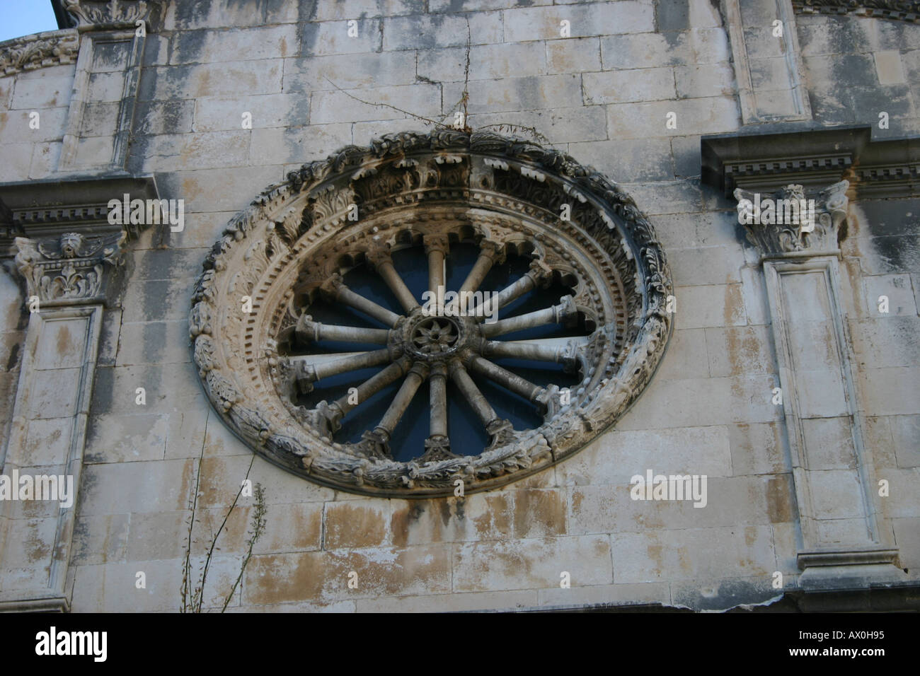 Round partitioned ornate stone and glass window in baroque building ...