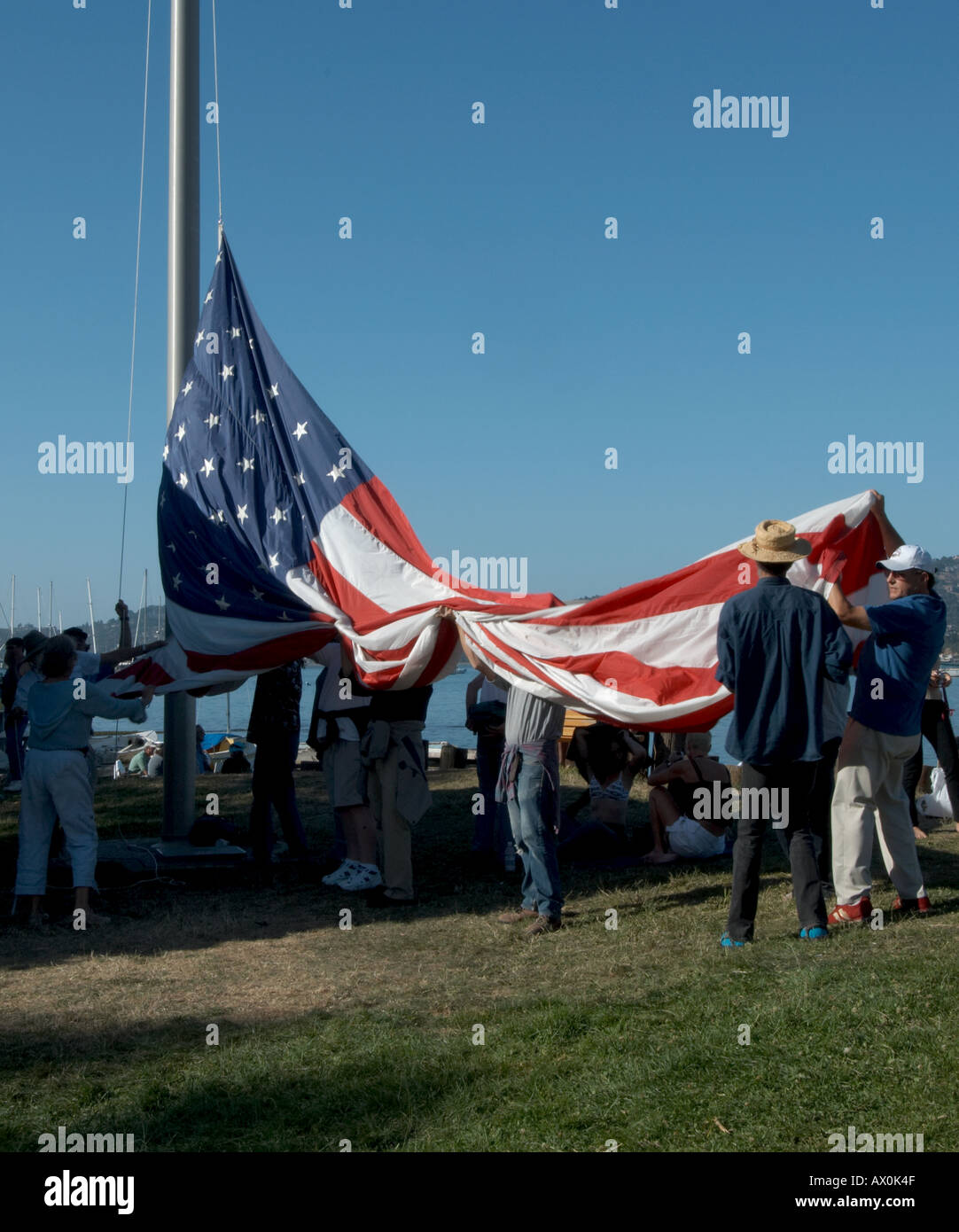 Group of citizens lowering and folding the American flag in sausalito ...