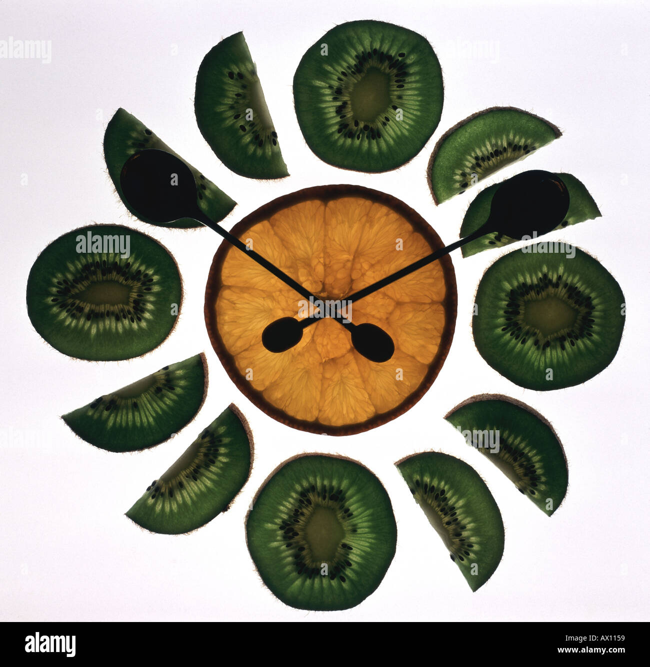 Fruit clock made with kiwi fruit sections and orange Stock Photo - Alamy