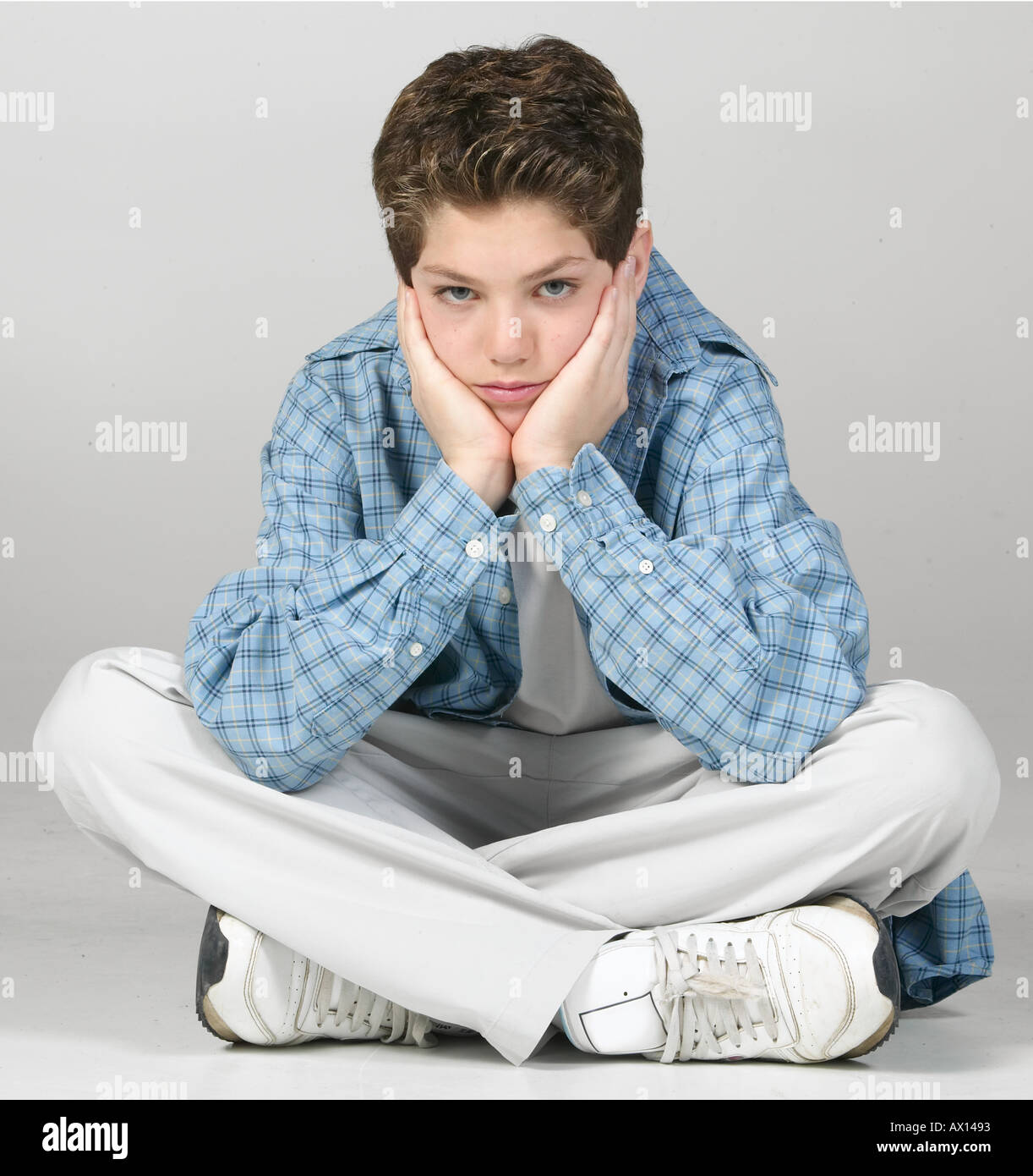 Bored teenager sitting cross legged Stock Photo - Alamy