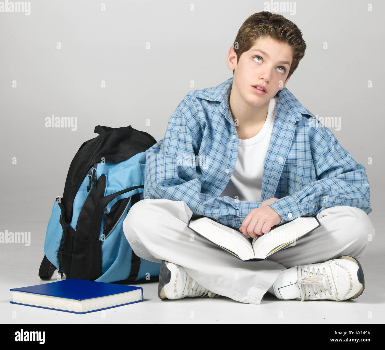 Thinking teenaged boy studying textbook Stock Photo - Alamy