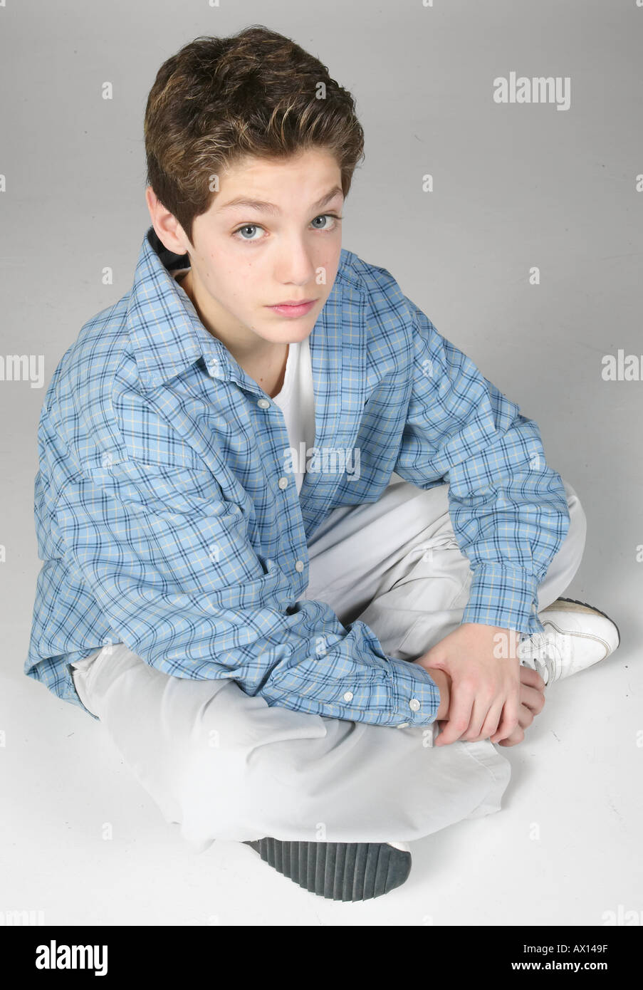 Teenaged boy sitting cross legged Stock Photo - Alamy