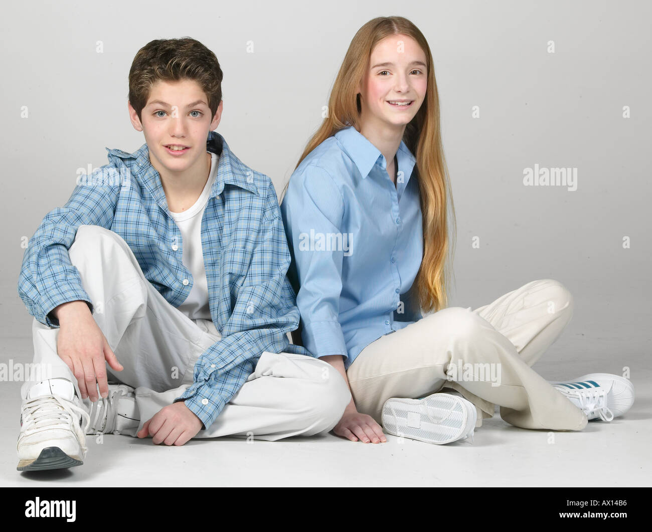 Smiling boy and girl sitting beside each other Stock Photo - Alamy