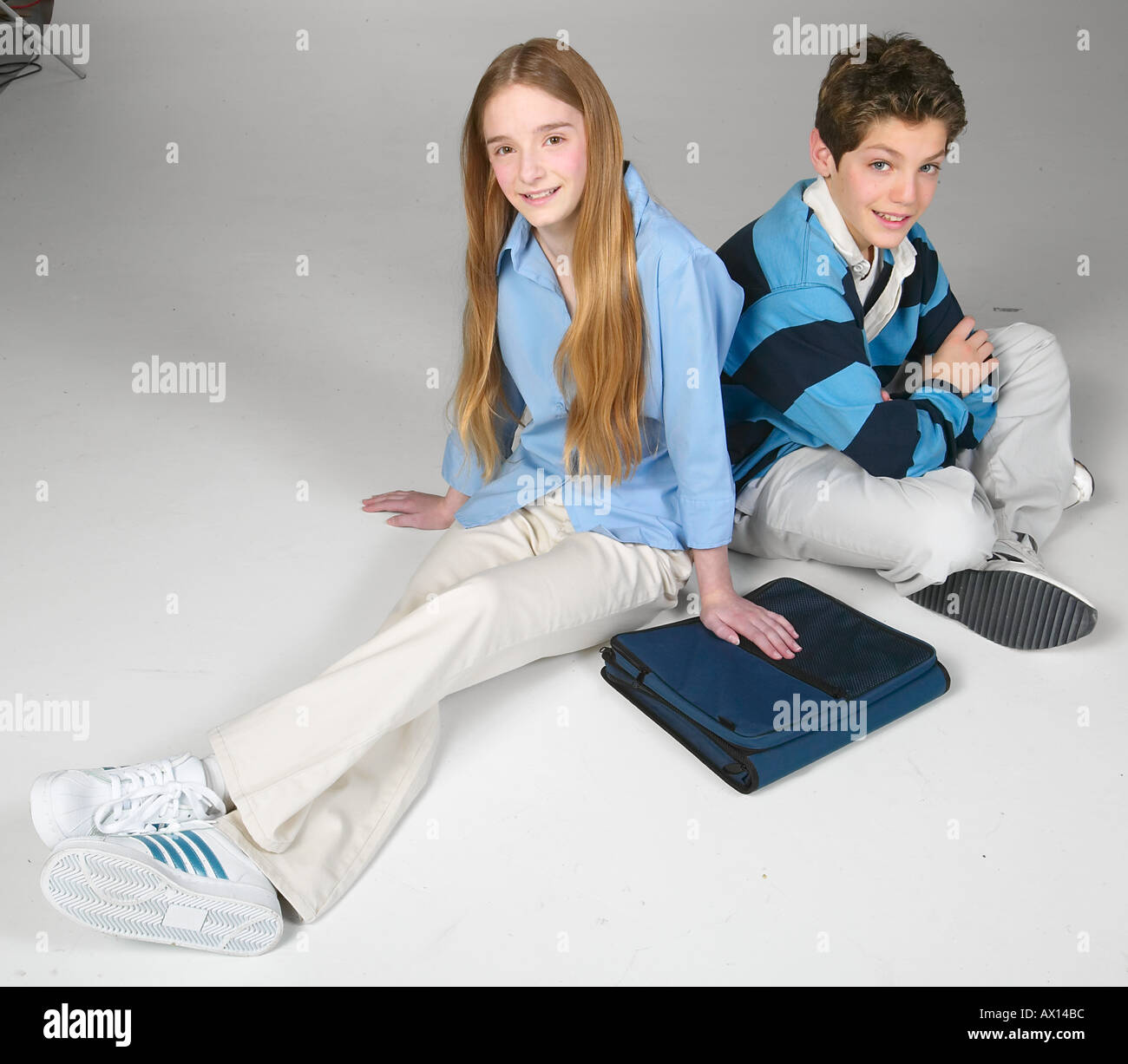 Smiling boy and girl sitting beside school book Stock Photo - Alamy