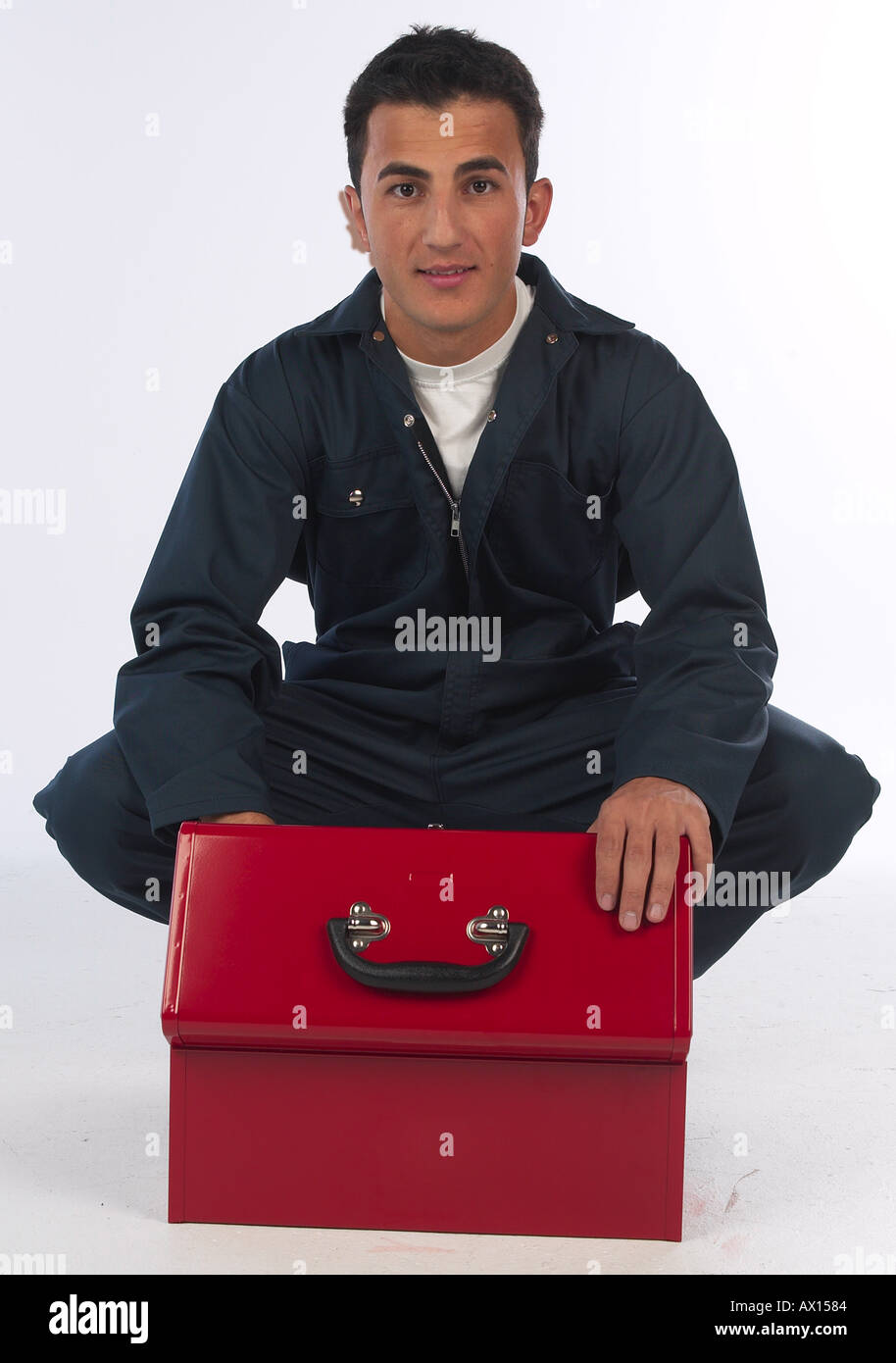 Mechanic kneeling over open toolbox Stock Photo - Alamy
