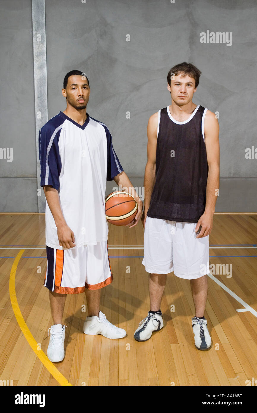 Two Young Men standing on a basketball court Stock Photo - Alamy