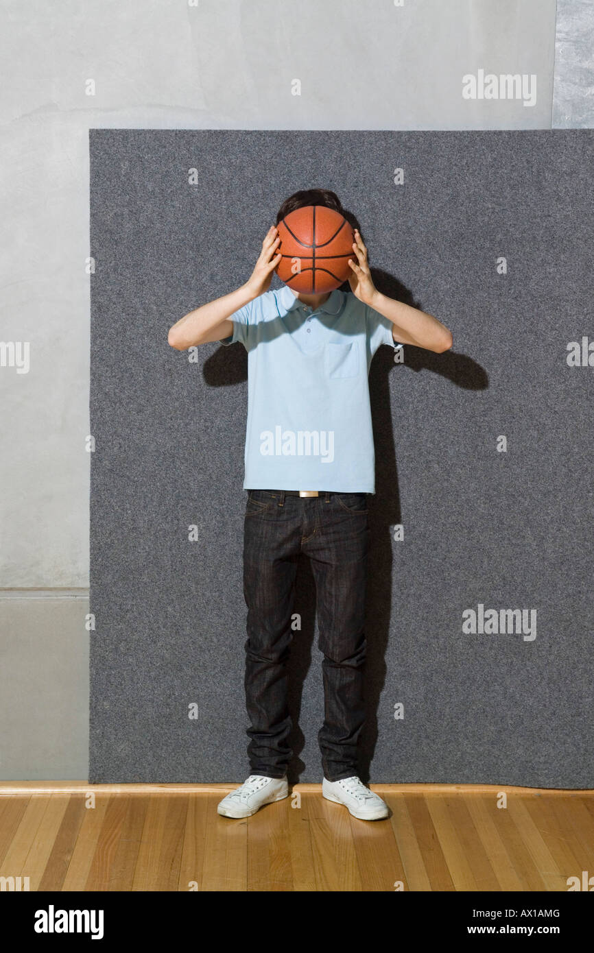 A man holding a basketball in front of his face Stock Photo - Alamy