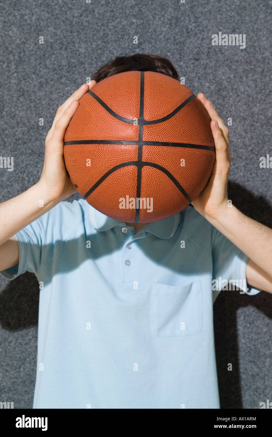 A man holding a basketball in front of his face Stock Photo - Alamy